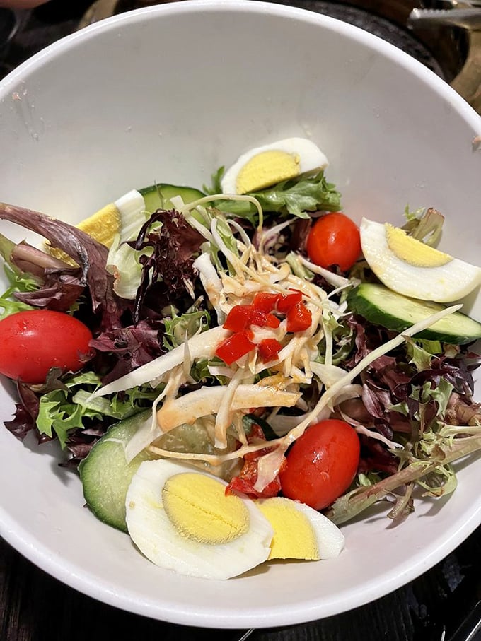A salad that actually excites—fresh greens playing host to a party of eggs, tomatoes, and cucumber in perfect harmony.