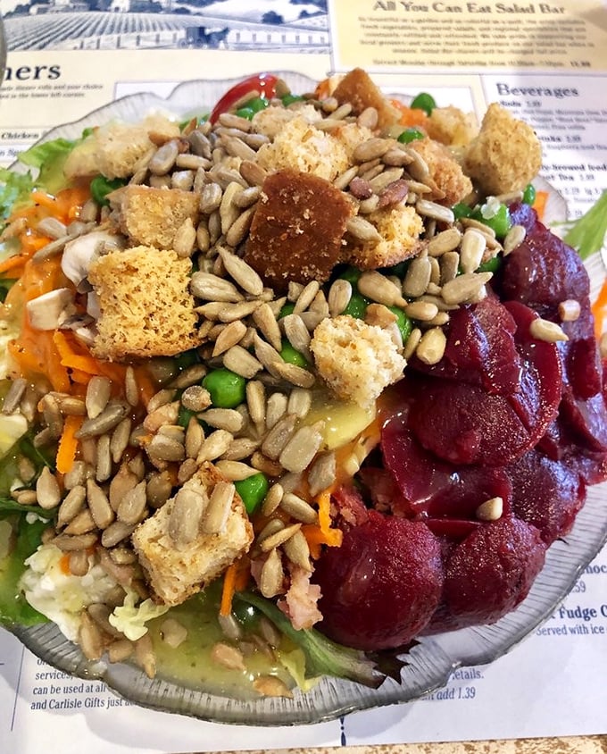 A salad that defies the "rabbit food" stereotype – loaded with sunflower seeds, croutons, and what appears to be pickled beets, bringing color and crunch to every bite.