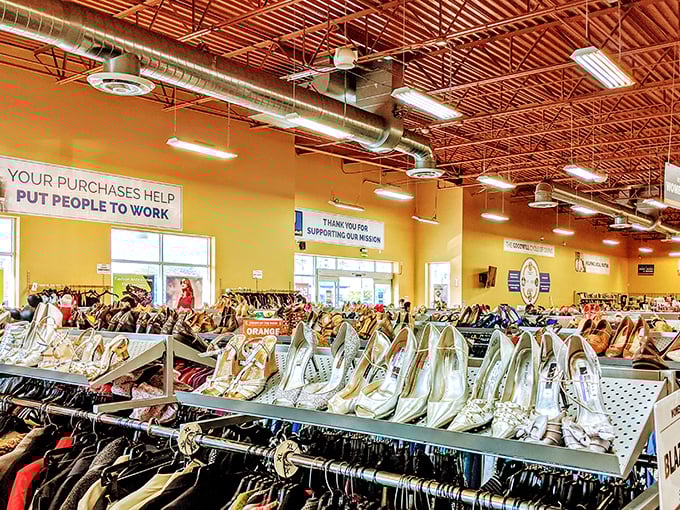 Rows of shoes organized by color because even thrift stores understand the importance of a pleasing visual shopping experience.