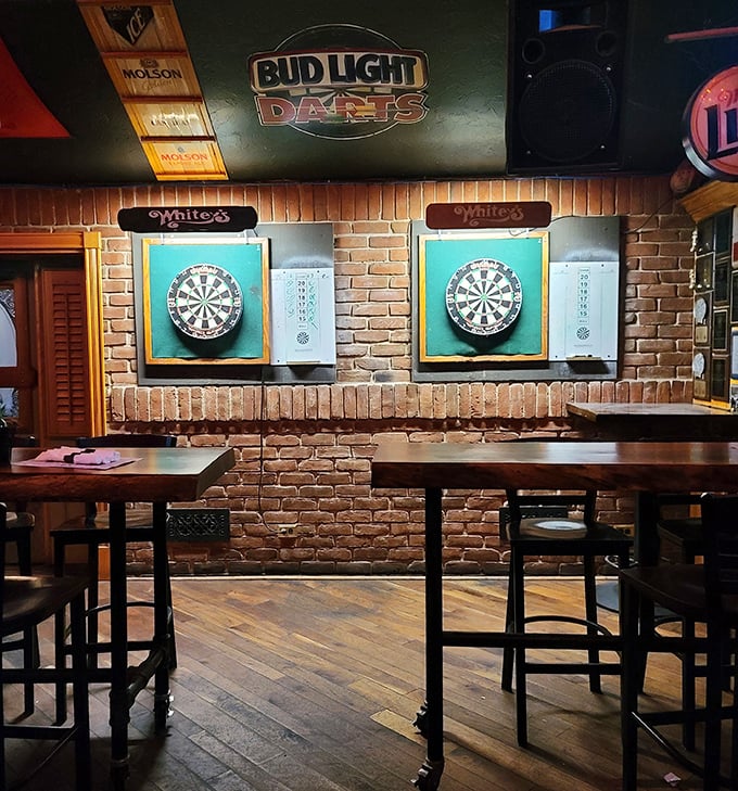 The dart area features brick walls and Whitey's-branded boards—where friendly competitions heat up almost as much as the grill.