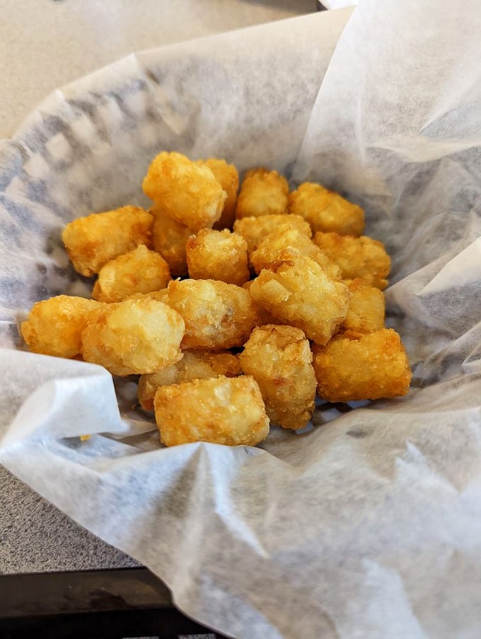 Golden tater tots nestled in paper—each one a perfect little time machine back to the best school lunch you ever had.