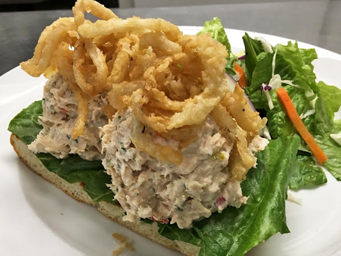 Tuna salad elevated to art form, crowned with crispy onion strings. This isn't your sad desk lunch—it's the sandwich equivalent of a standing ovation.