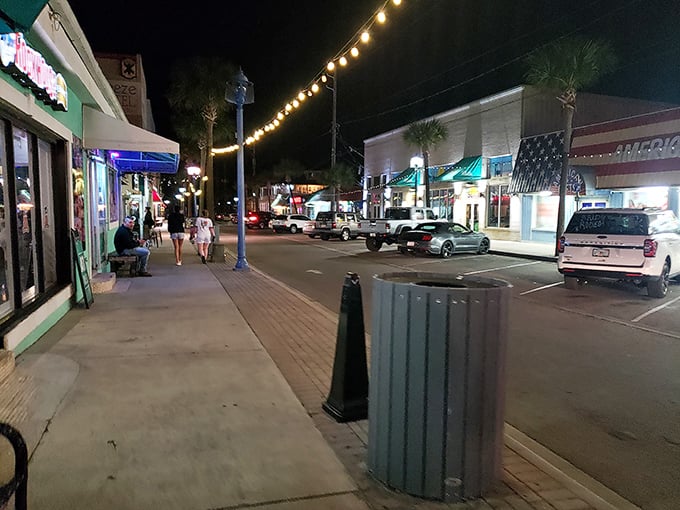 Tybee after dark—where string lights transform ordinary sidewalks into runways of possibility and the night air tastes like salt, freedom, and fried shrimp.